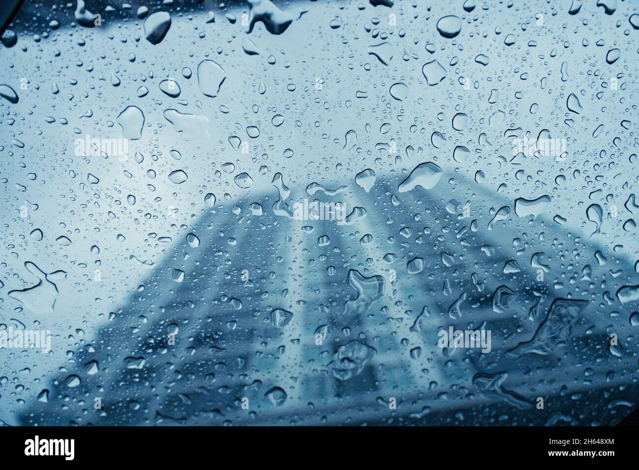 wet cool water drop with city office building background in rainy ...