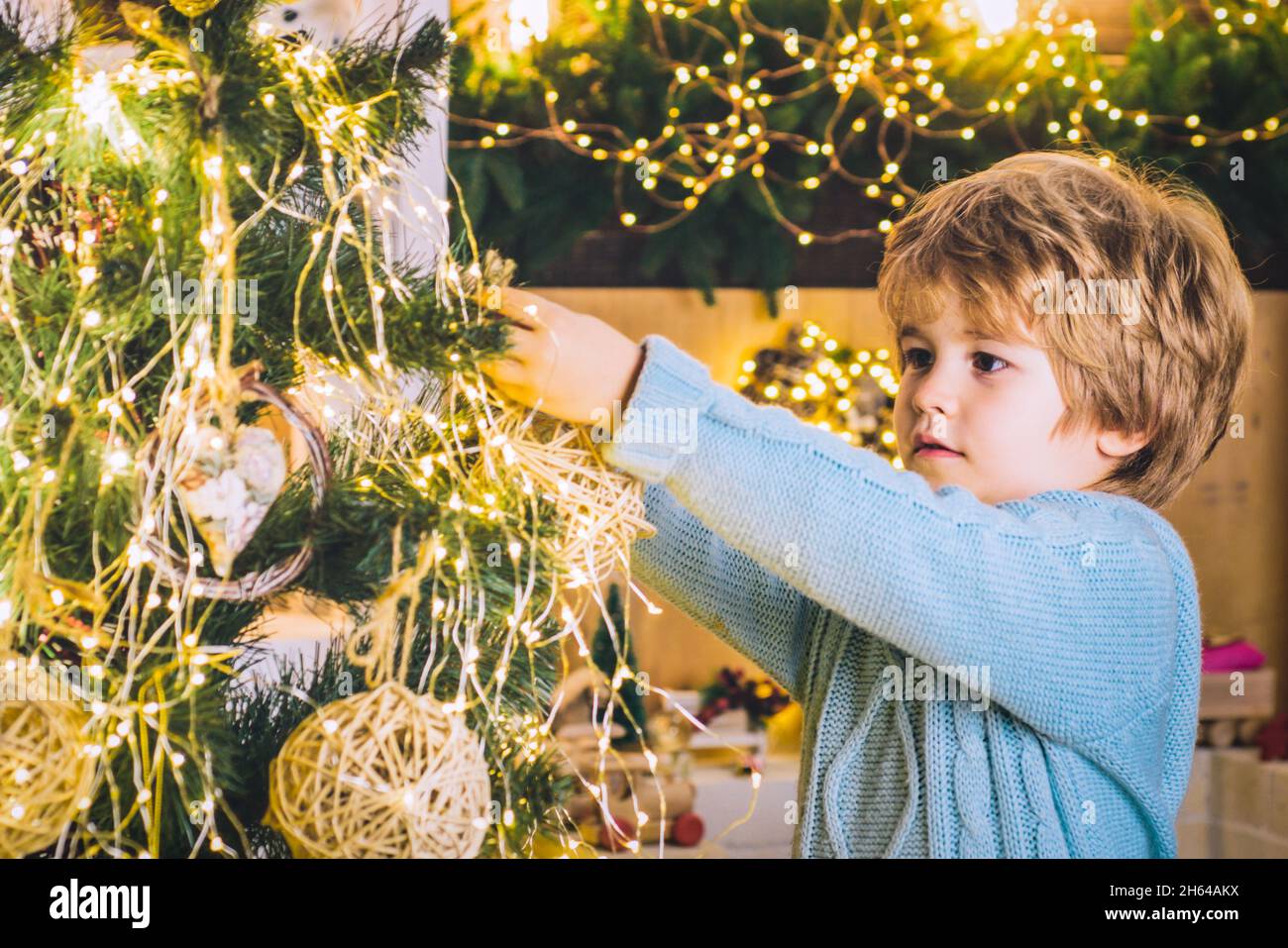 Kid decorating Christmas tree with bauble. Portrait of Santa kid boy ...