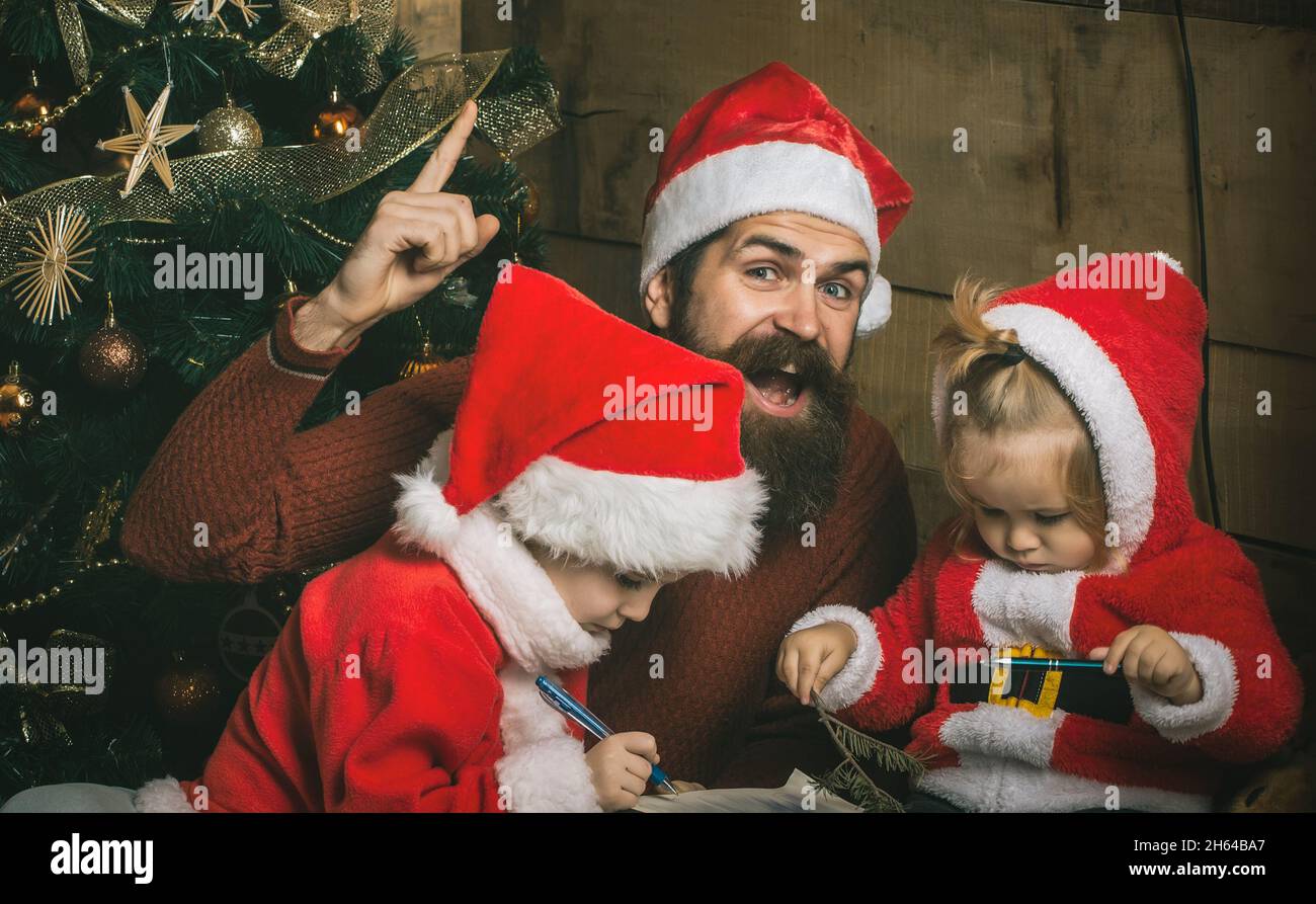 Santa claus with kids at Christmas tree. Xmas celebration, fathers day ...