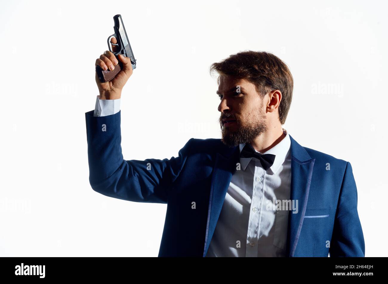 male Agent with a gun in hand Studio emotions Stock Photo - Alamy