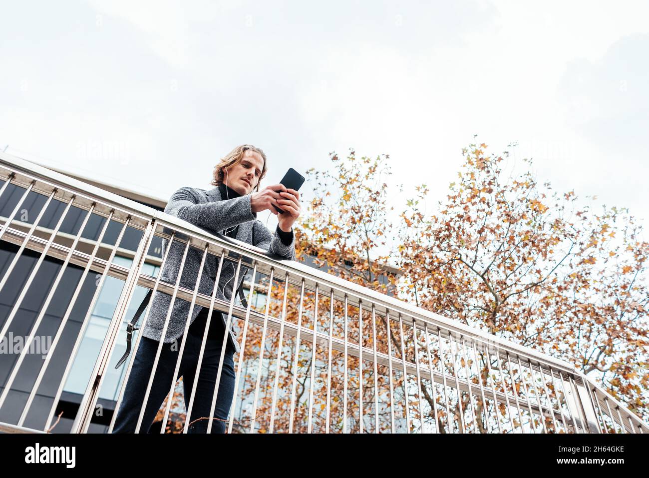 Modern businessman with smartphone in his hands on a city street ...