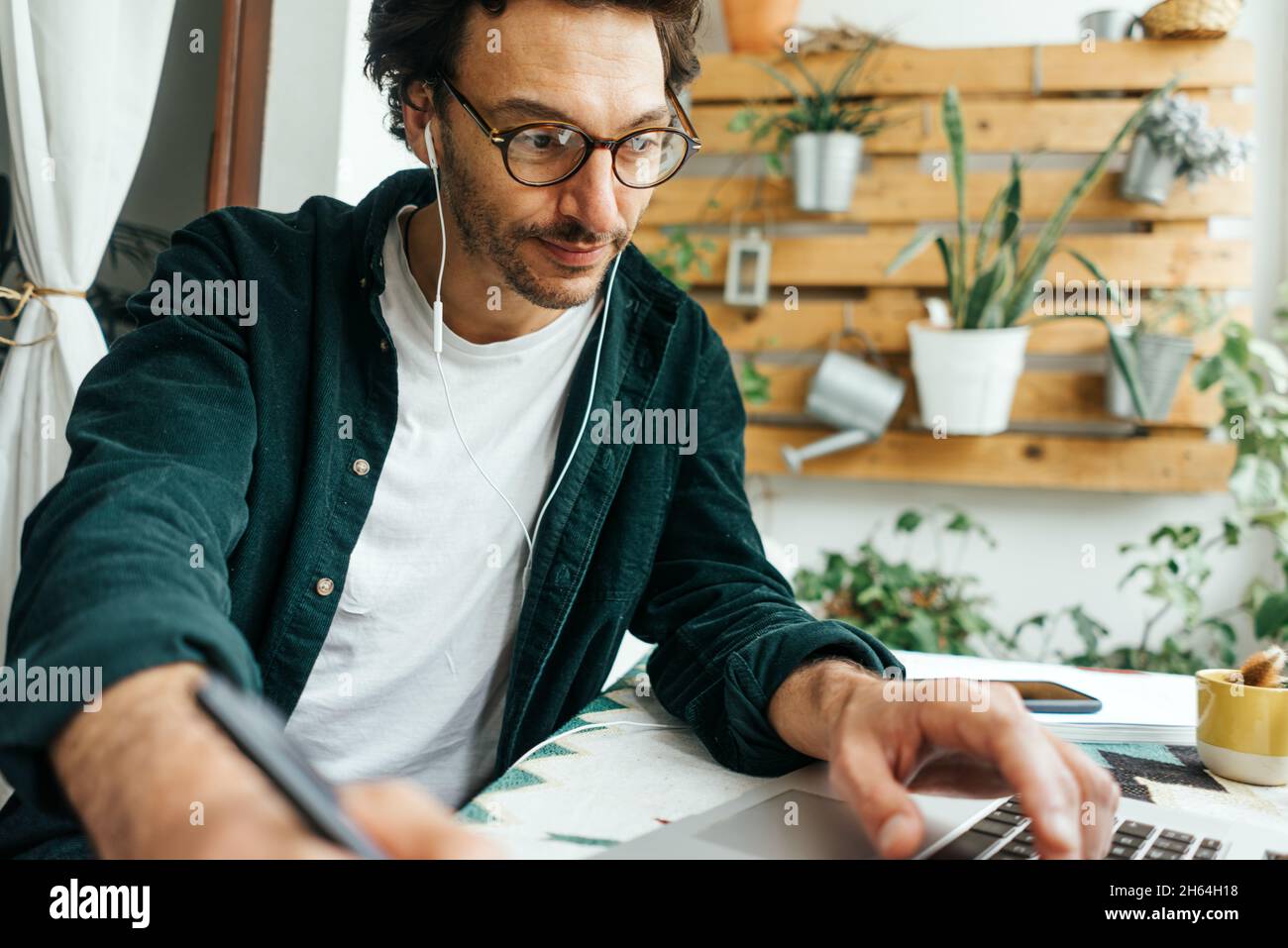 Handsome man with laptop working remotely from home. Freelancer at ...