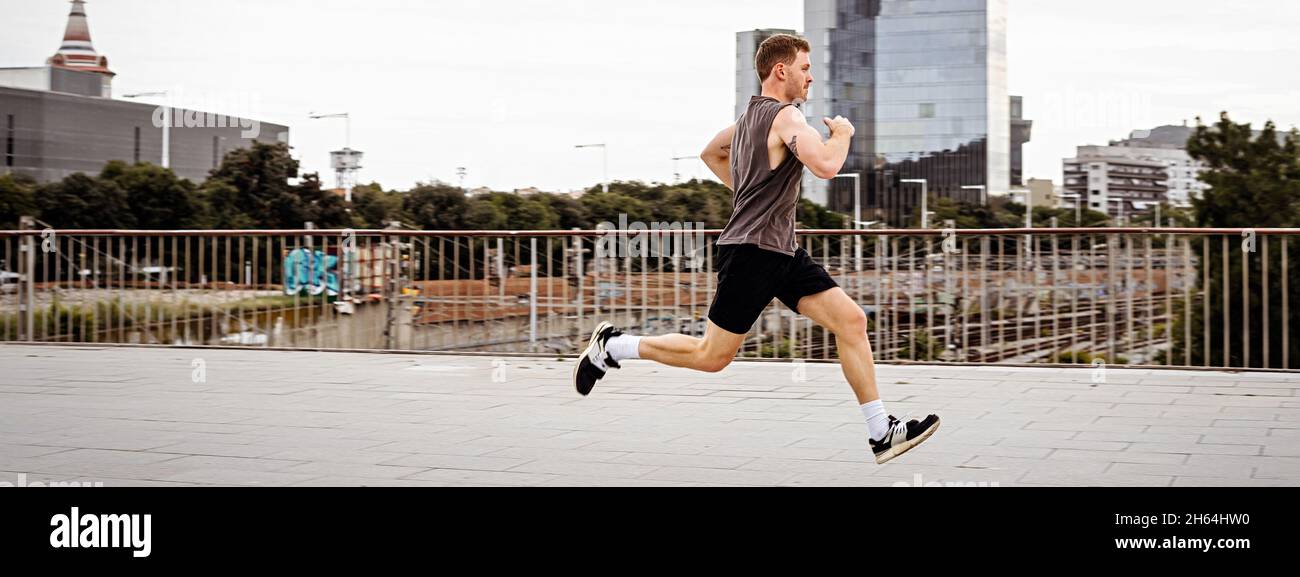 Fit young man running. Male runner jogging early in the morning ...