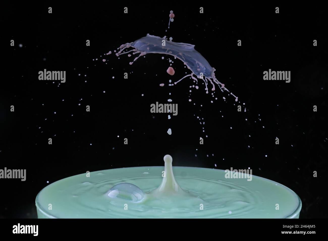 A drop of milk falls into a cup Stock Photo - Alamy