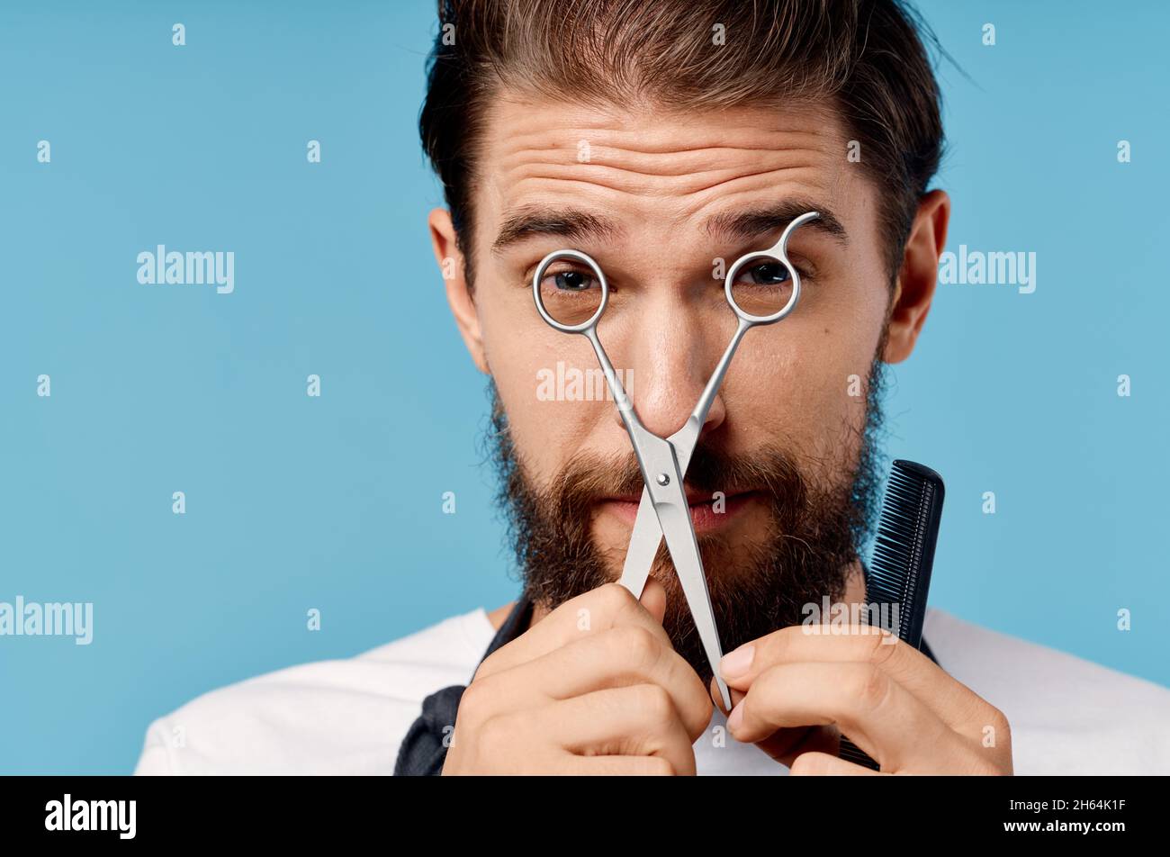 male hairdresser barbershop haircut blue background Stock Photo - Alamy