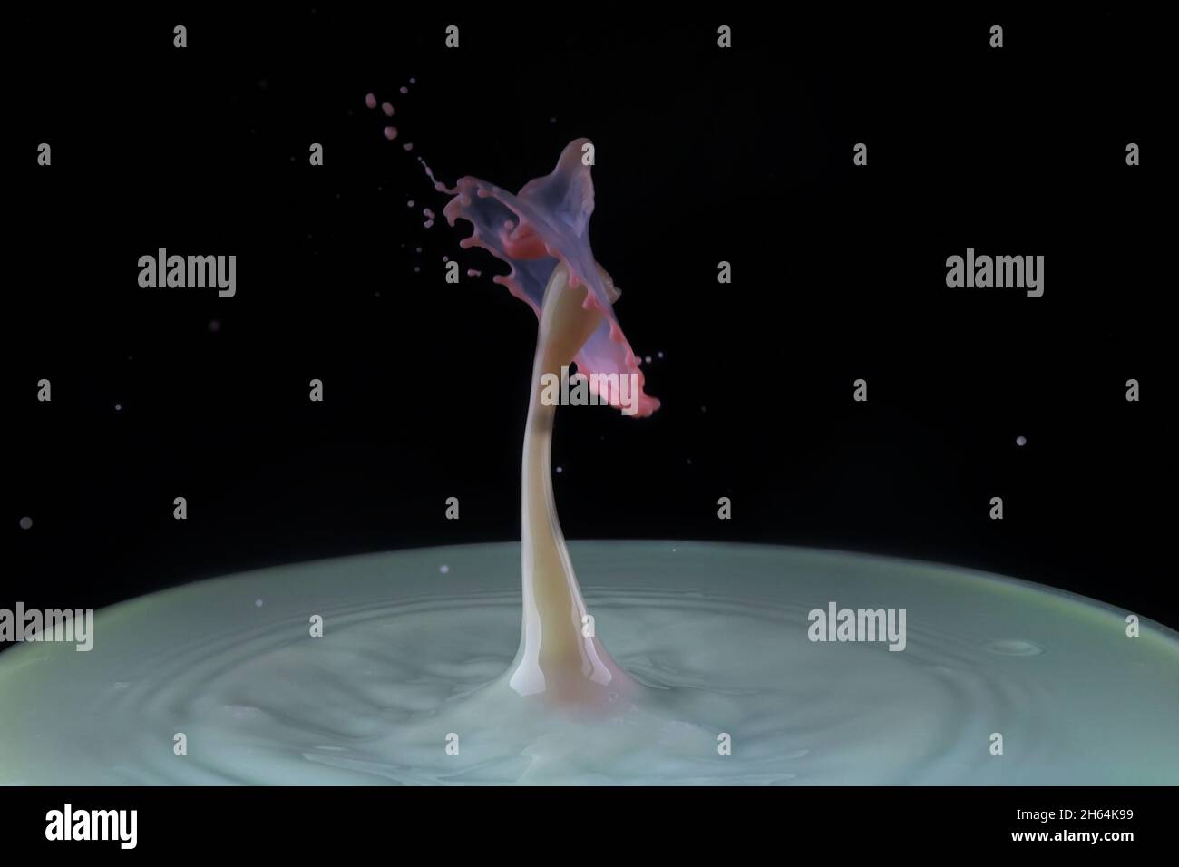 A drop of milk falls into a cup Stock Photo - Alamy