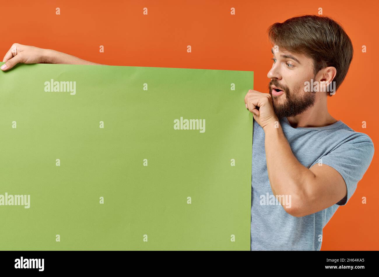 bearded man holding a green banner design orange background Stock Photo ...