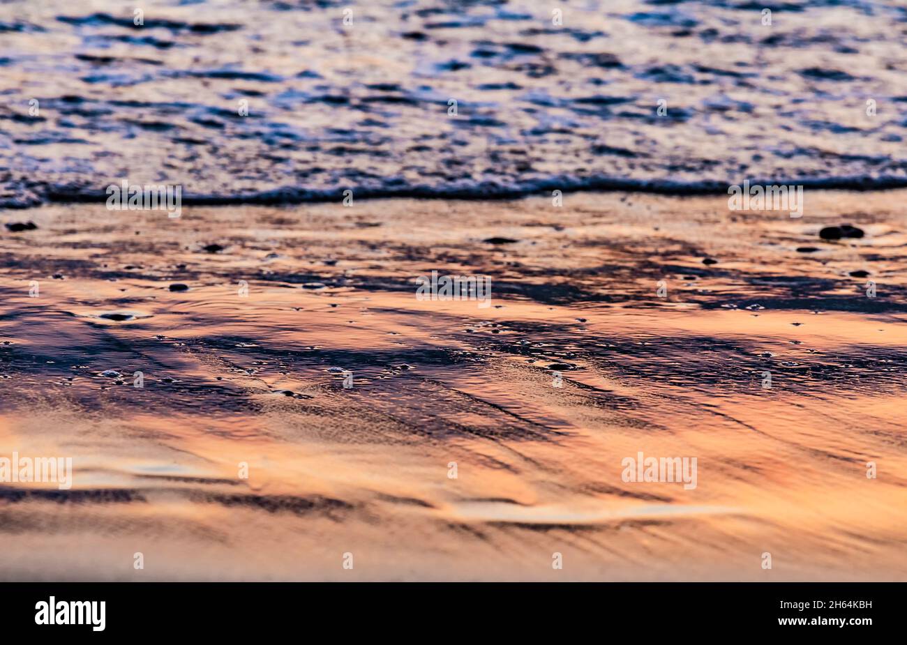 Sea water edge at sunset or sunrise. Texture of waves and sand in the ...