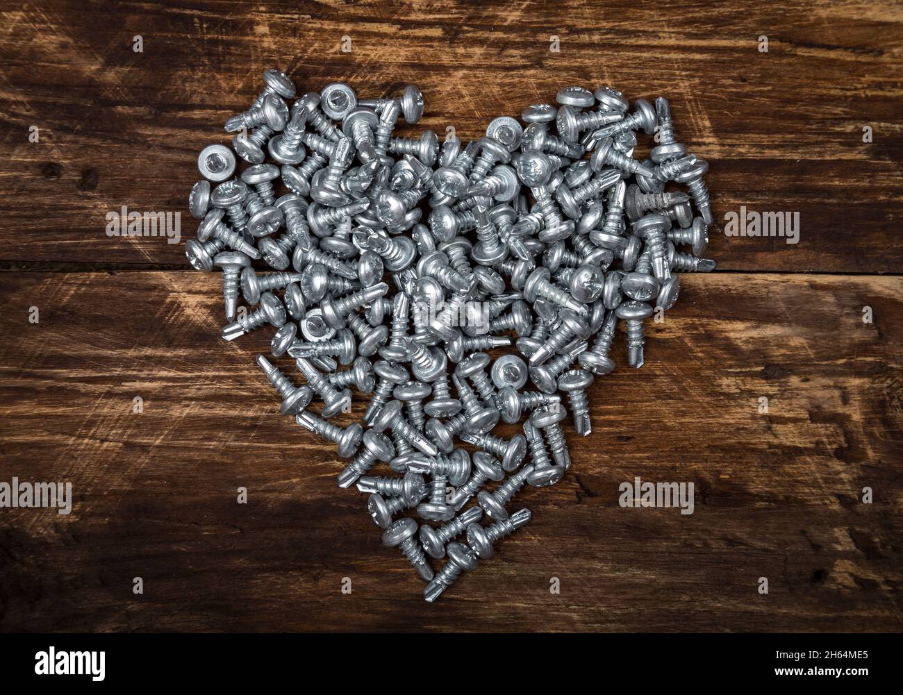 A heart shaped figure laid out from silver color screws on vintage ...