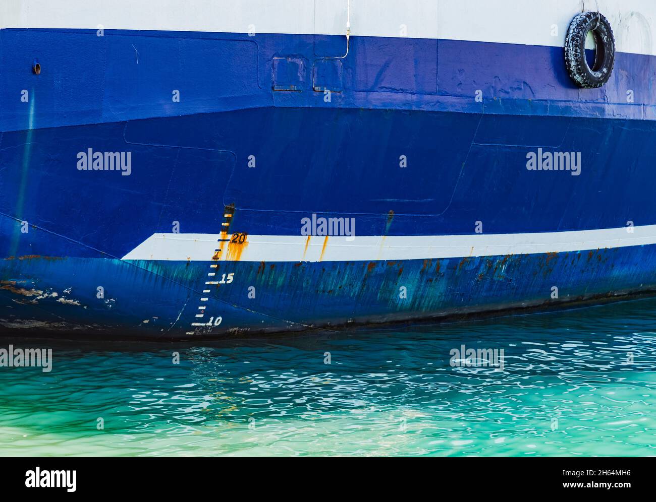 Side of blue cargo ship hull with white waterline and numbers of rough ...