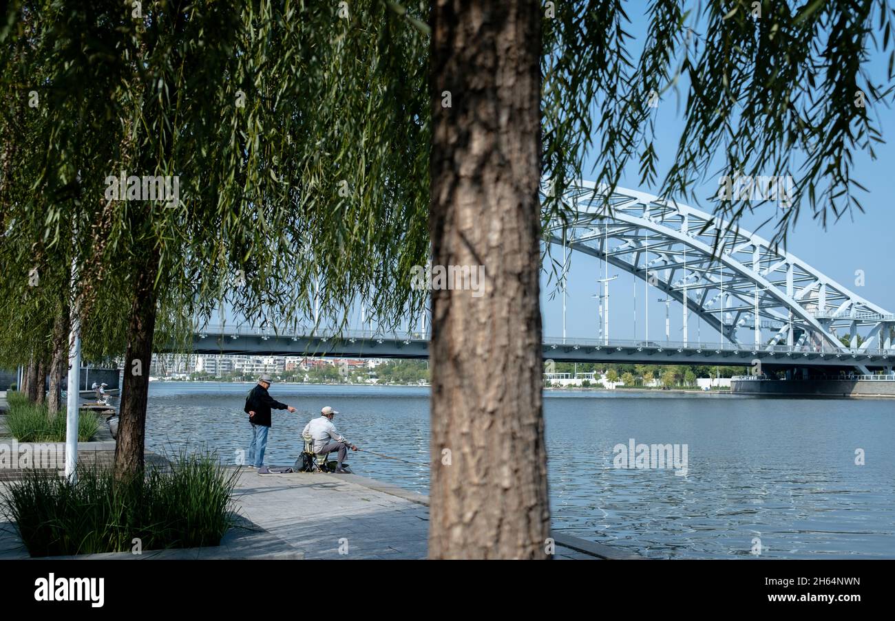 Retired men go fishing beside river Stock Photo - Alamy
