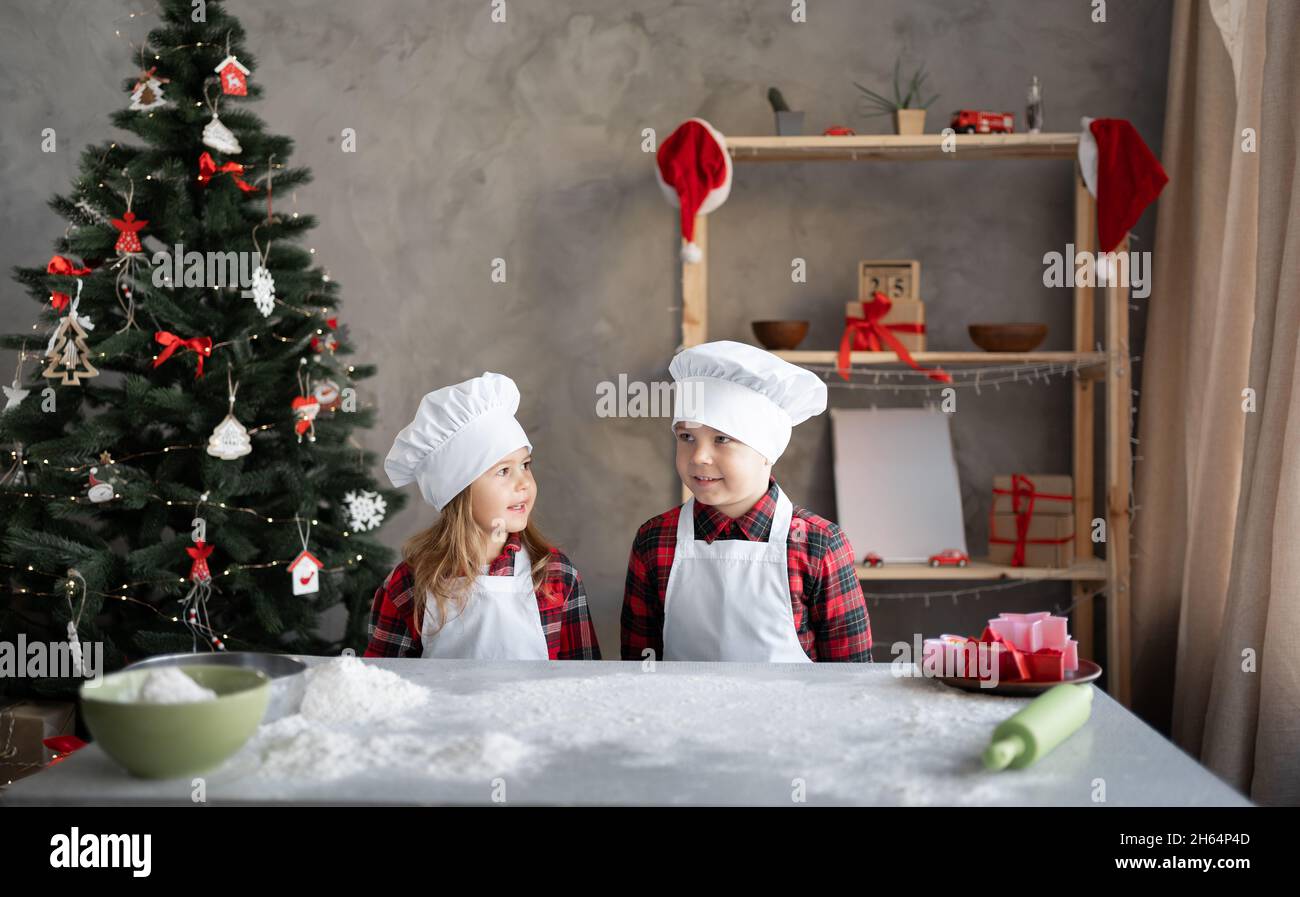 Pretty Caucasian children bakers in the kitchen made flour for ...