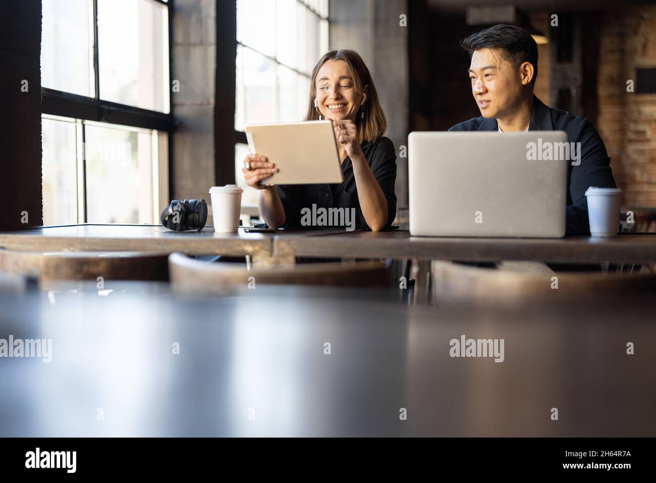 Man show something on laptop to woman in cafe Stock Photo - Alamy