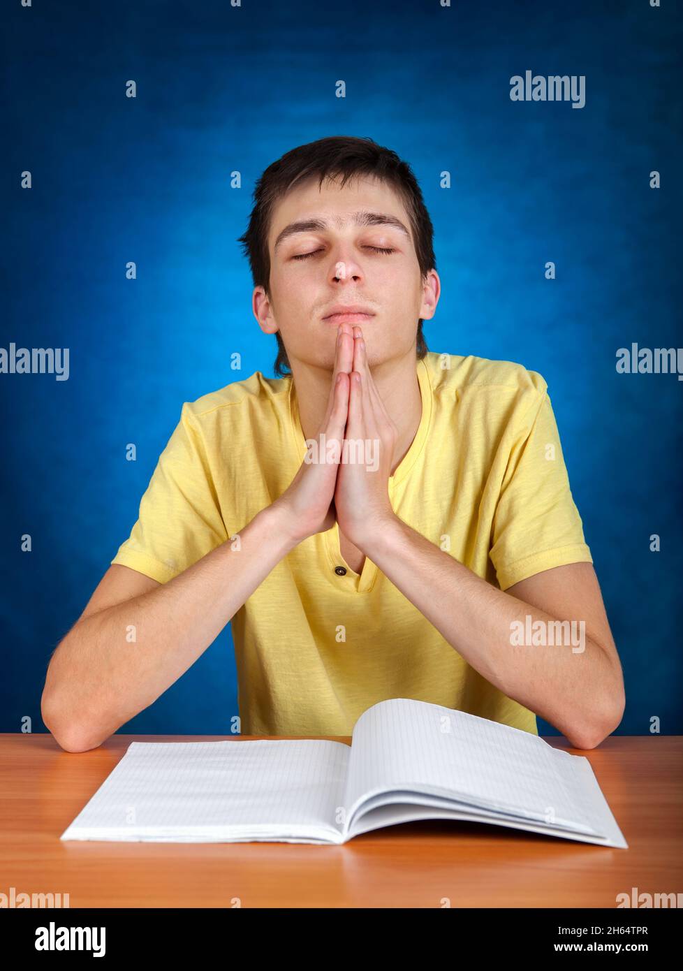 Young Man praying on the Blue Background Stock Photo - Alamy