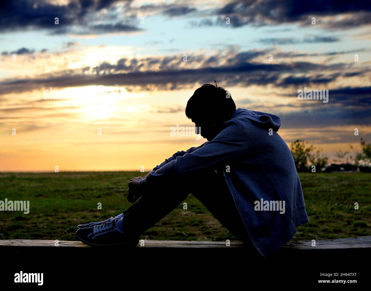 Sad Teenager Silhouette at the Sunset Background Stock Photo - Alamy