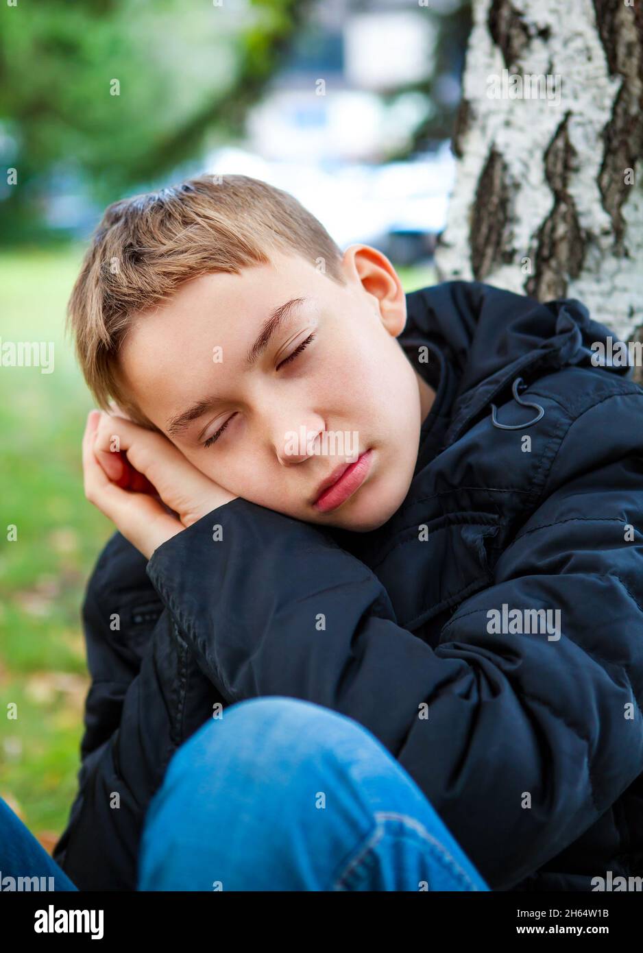 Boy sleeping under tree hi-res stock photography and images - Alamy