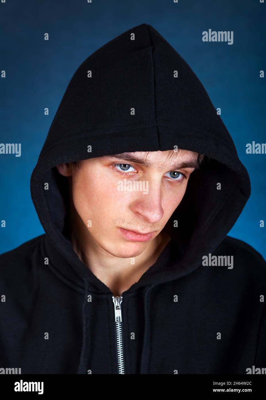 Sad Young Man in the Hood on the Dark Background Stock Photo - Alamy