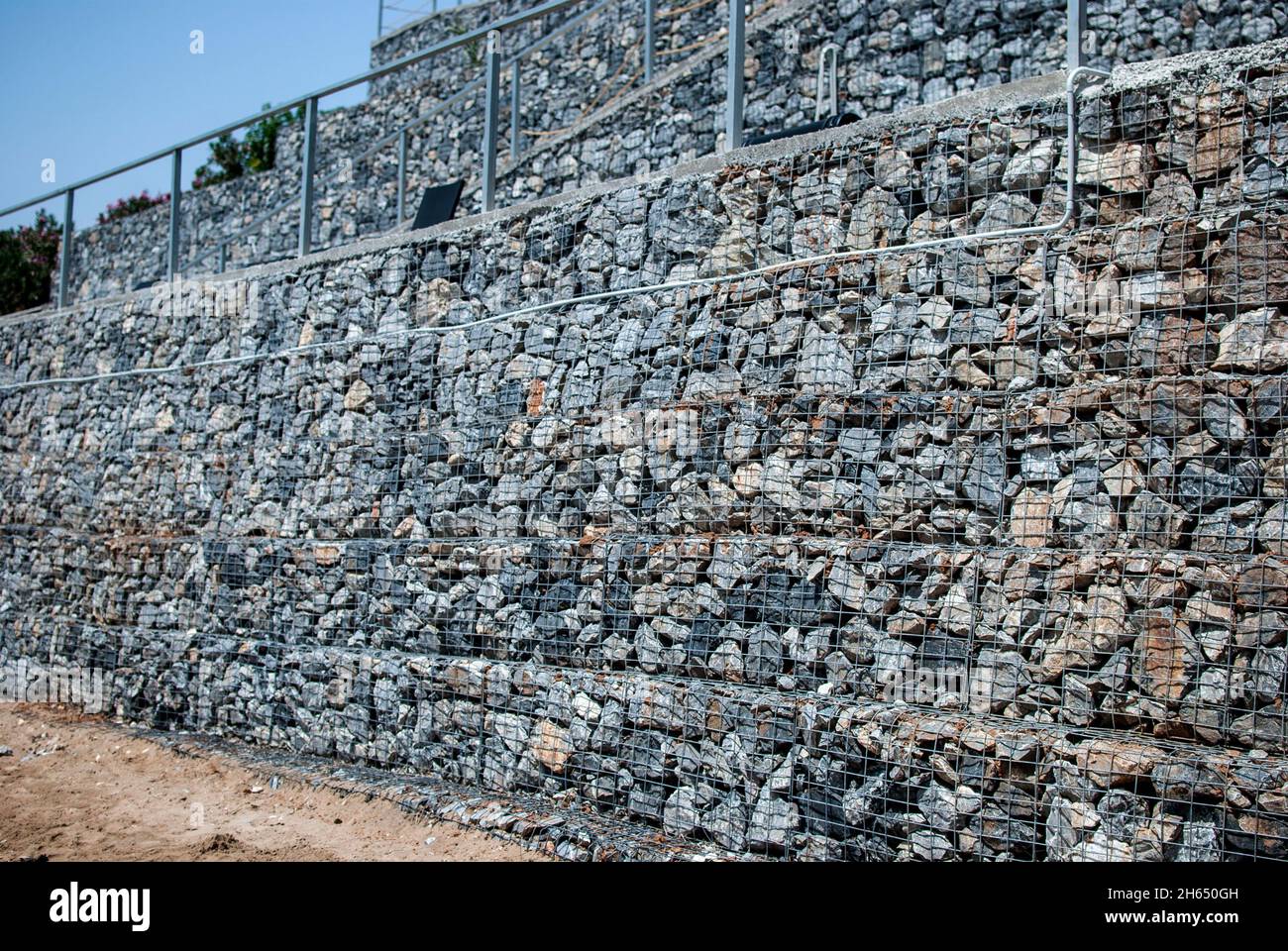 Galvanized gabion mesh stone wall closeup in summer day Stock Photo - Alamy