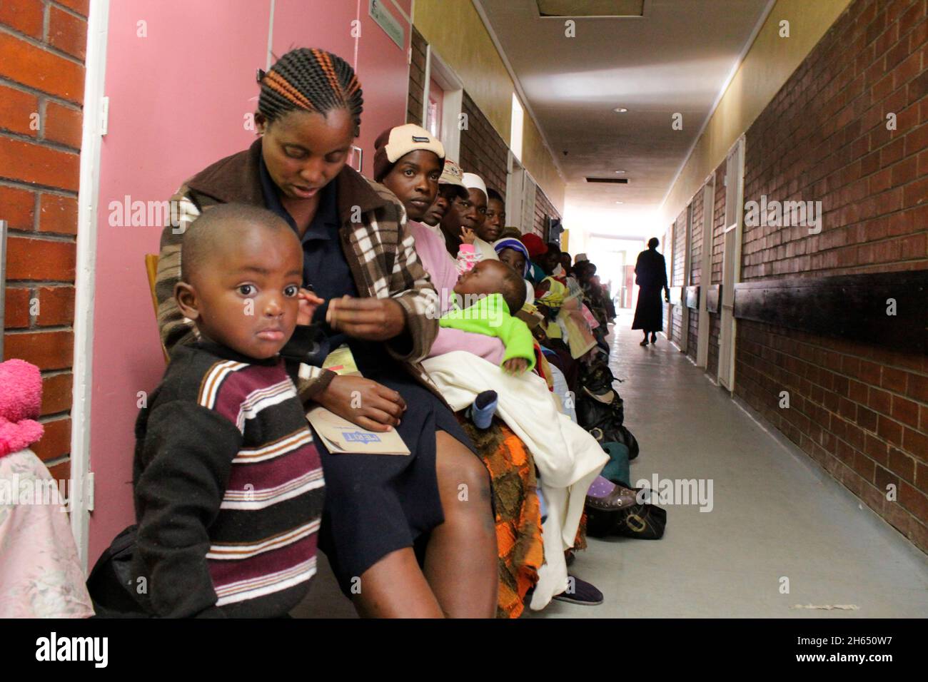 Scores of mothers wait with their children to be screened for operation ...