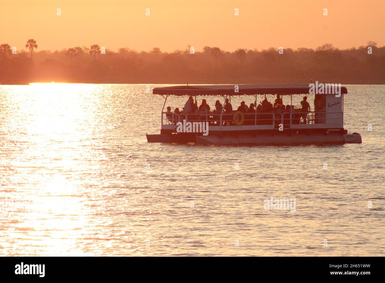 A big boat with tourists is seen cruising on the Zambezi river at ...