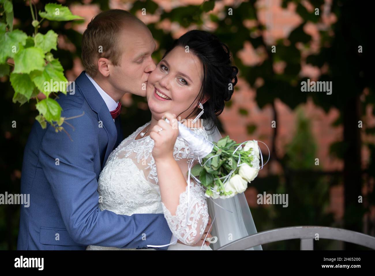 The groom kisses the happy fat bride Stock Photo - Alamy