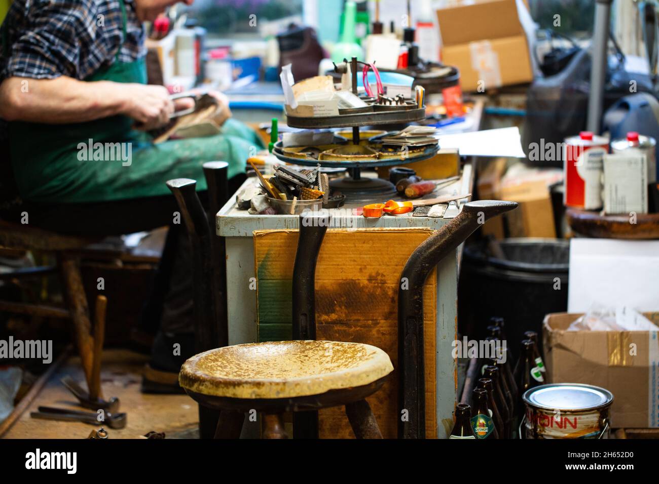 Shoemaker workshop with master shoemaker, old-fashioned workshop, orthopedic master at work ...