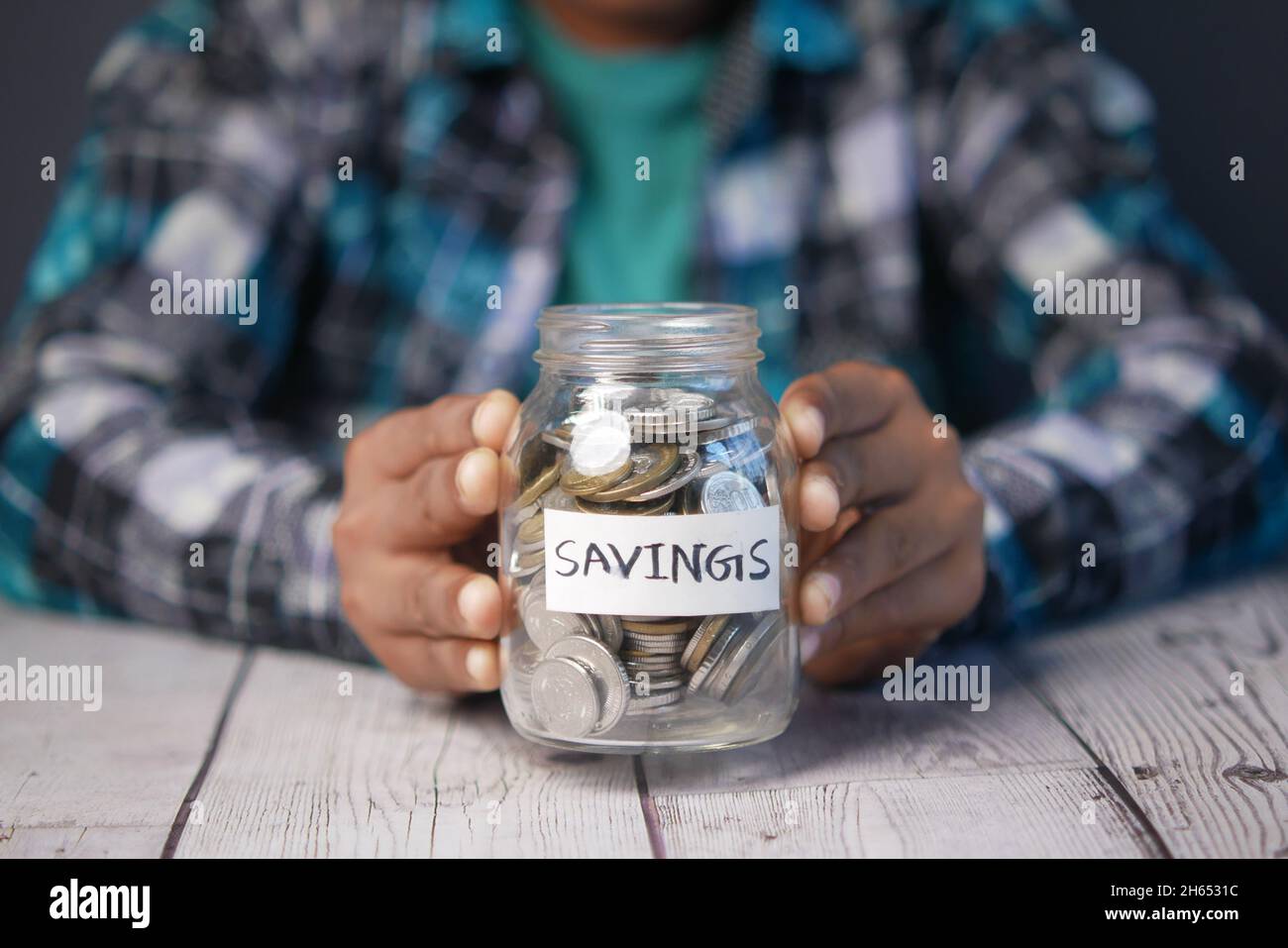 child boy hand hold a saving coins jar Stock Photo - Alamy
