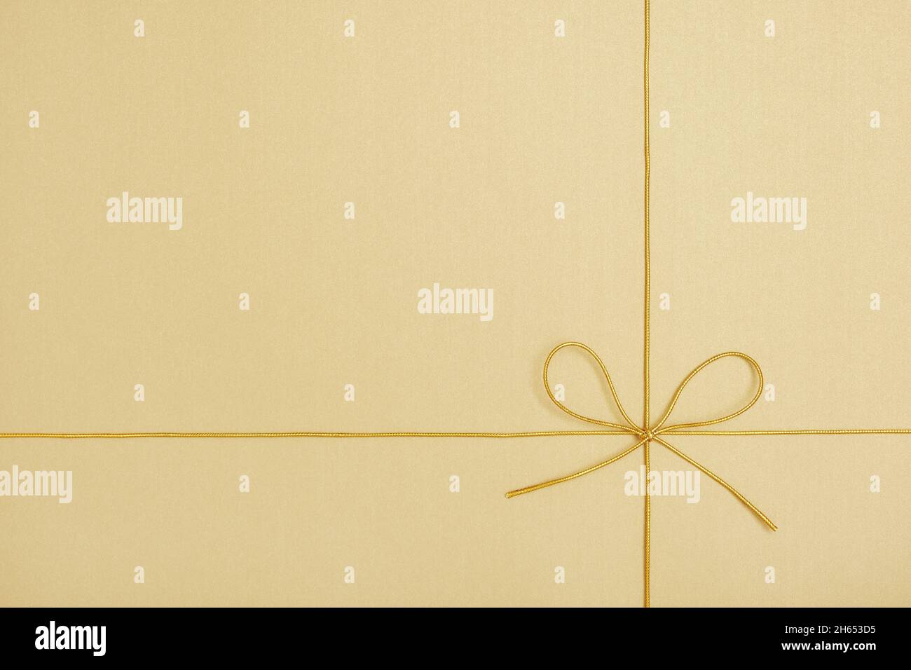 Shiny golden string tied in a bow on yellow background Stock Photo - Alamy