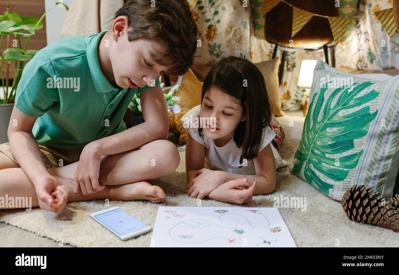 Brothers playing treasure hunting game in a diy tent at home Stock ...