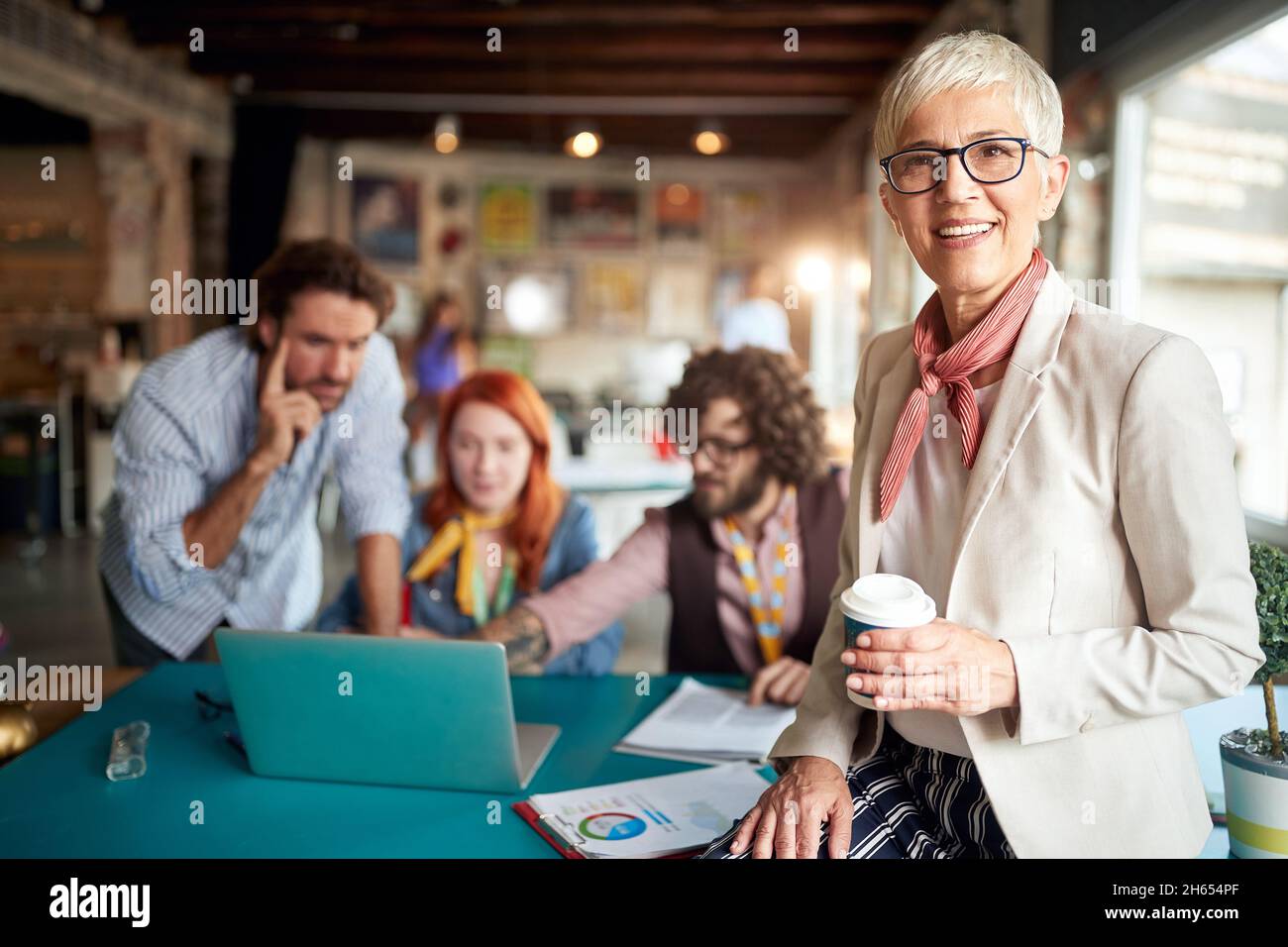 Group of young coworkers consulting with senior colleague Stock Photo ...