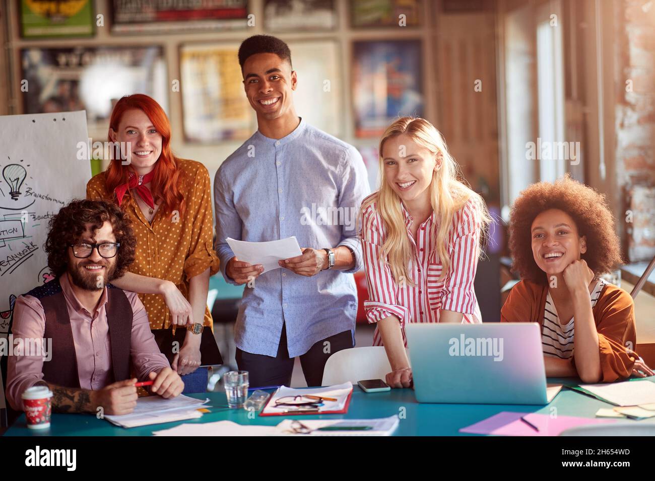 Group of happy employees are posing for a photo while working in a ...