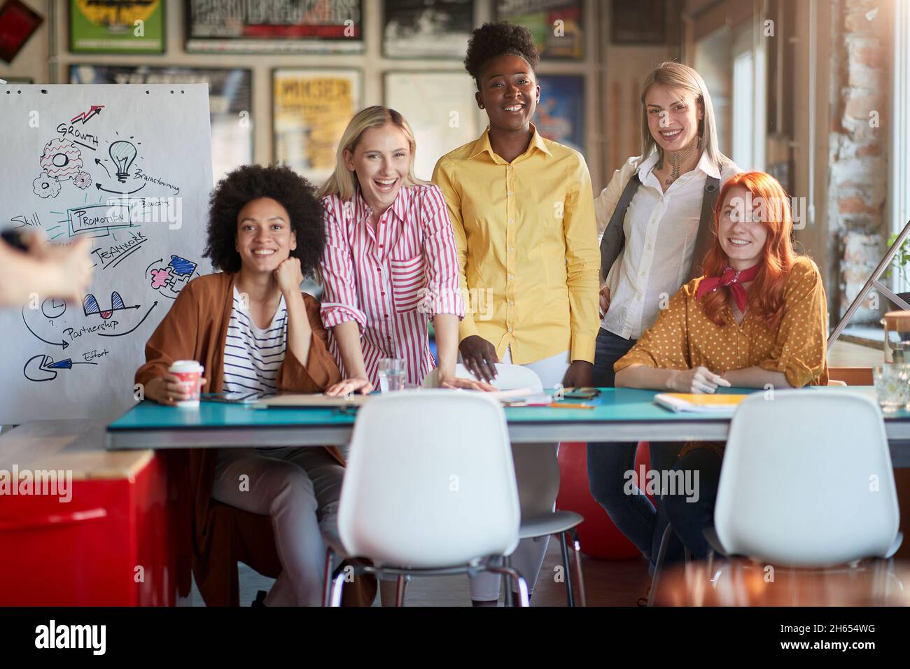 Group of beatiful female employees are posing for a photo in a pleasant ...