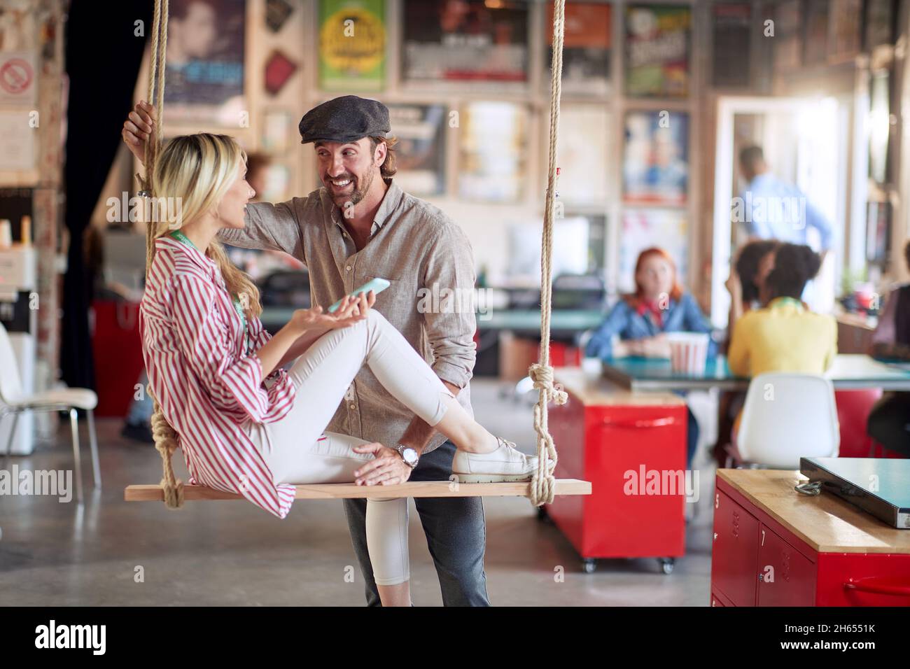 A young handsome man is flirting with his beautiful female colleague in ...