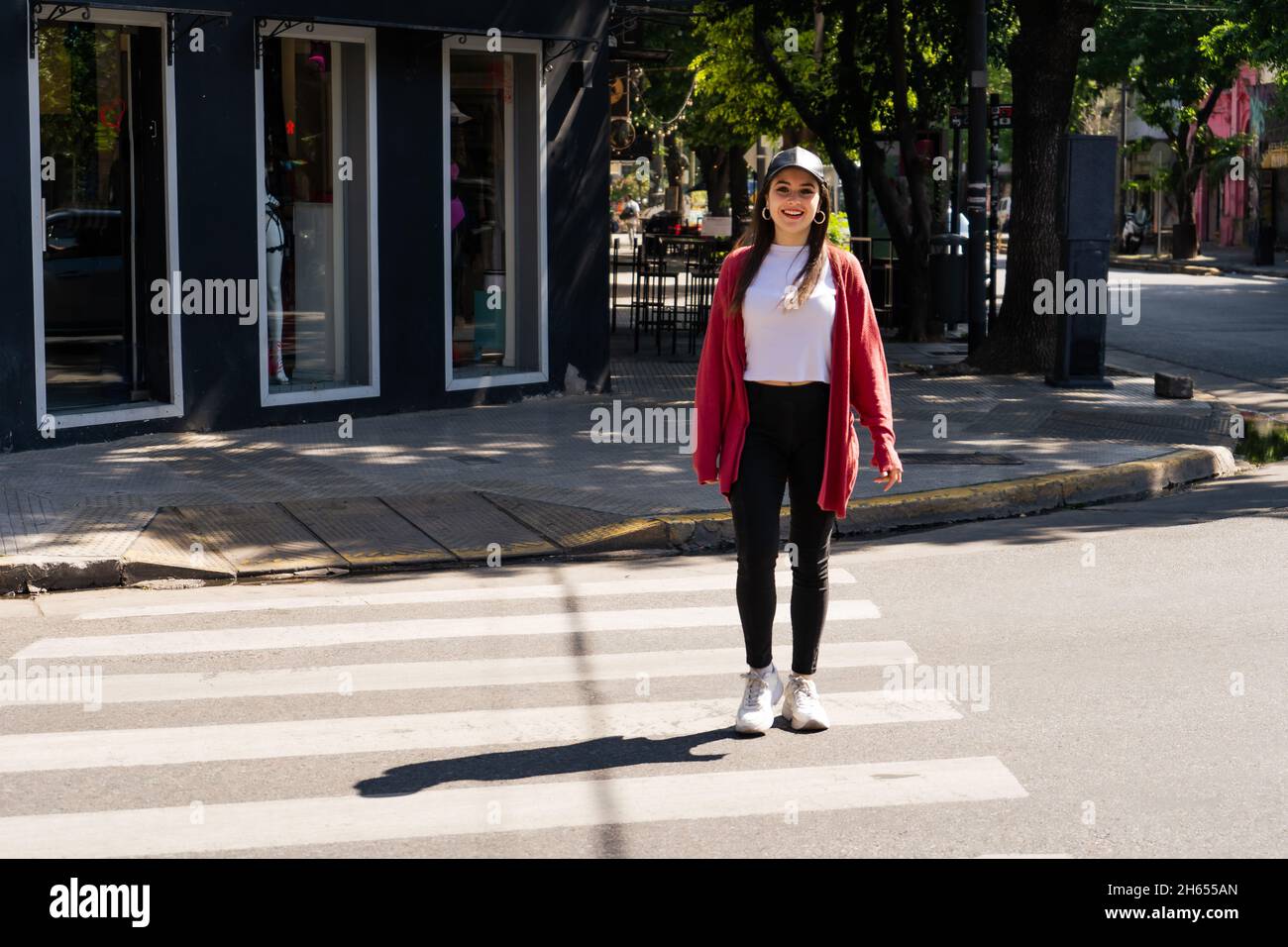 Portrait of a Young millennial woman crossing the street on the ...
