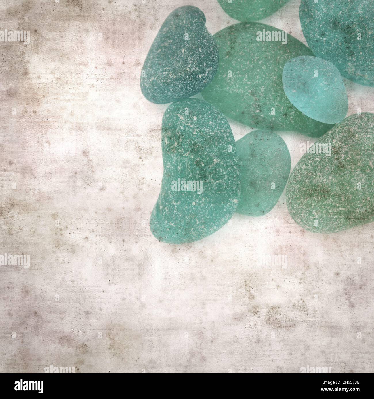 stylish textured old paper background with sea glass pebble pieces ...