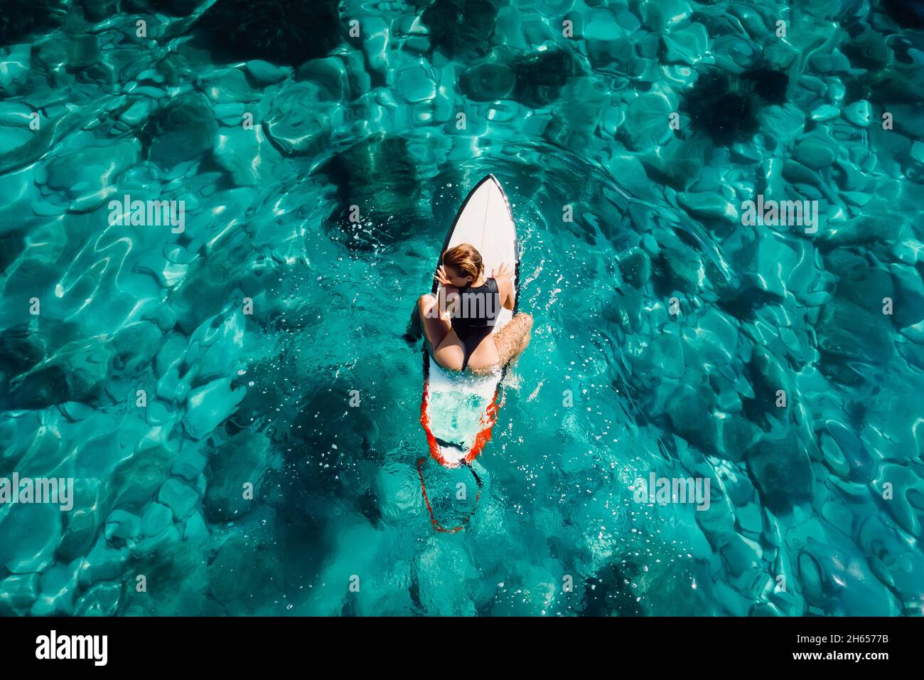 Surf girl on surfboard wait wave in transparent ocean. Aerial view with ...