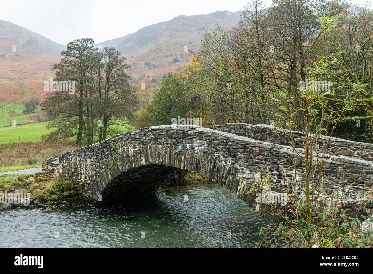 Attractive footbridge built of slate stone across the Derwent River ...