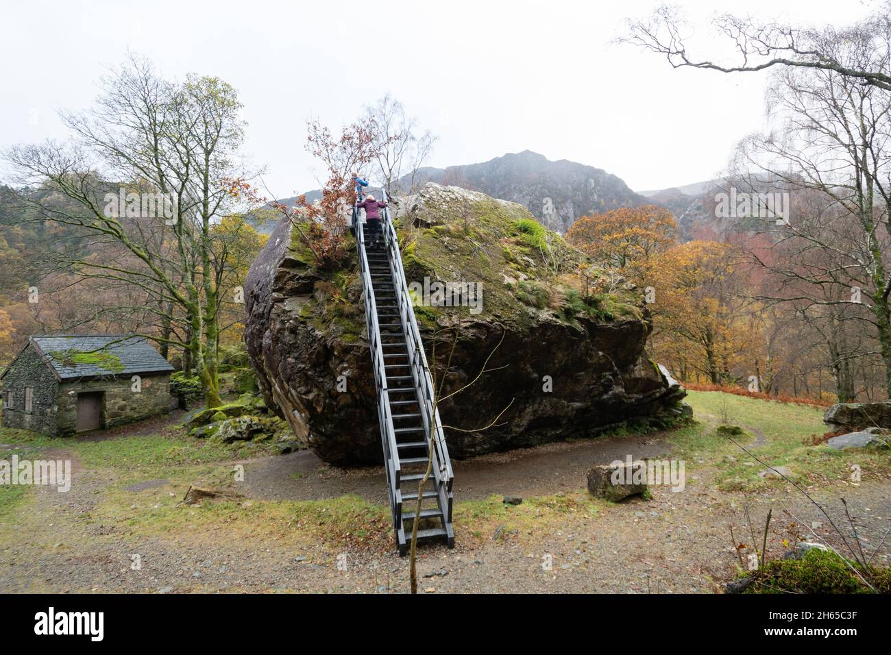 The Bowder Stone with visitors climbing up, a large andesite lava ...