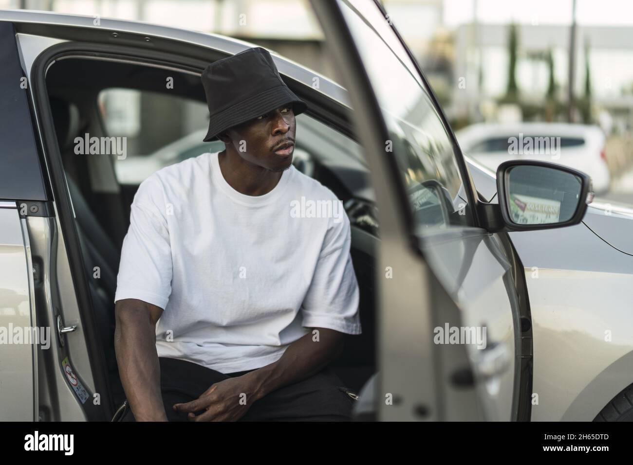 Cool young black male in a street style outfit posing in a car Stock ...