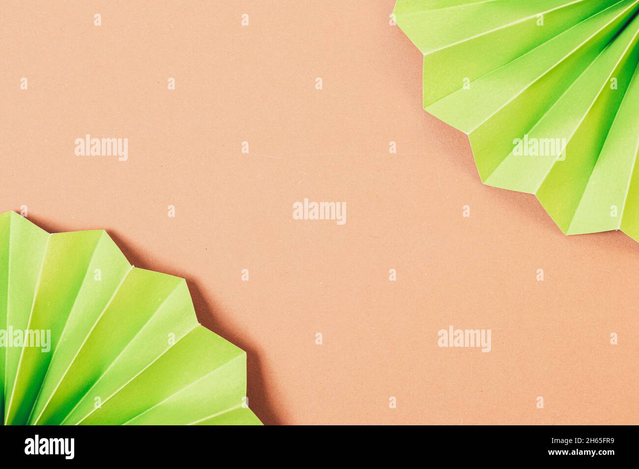Flat lay composition festive green paper fans on brown background with ...