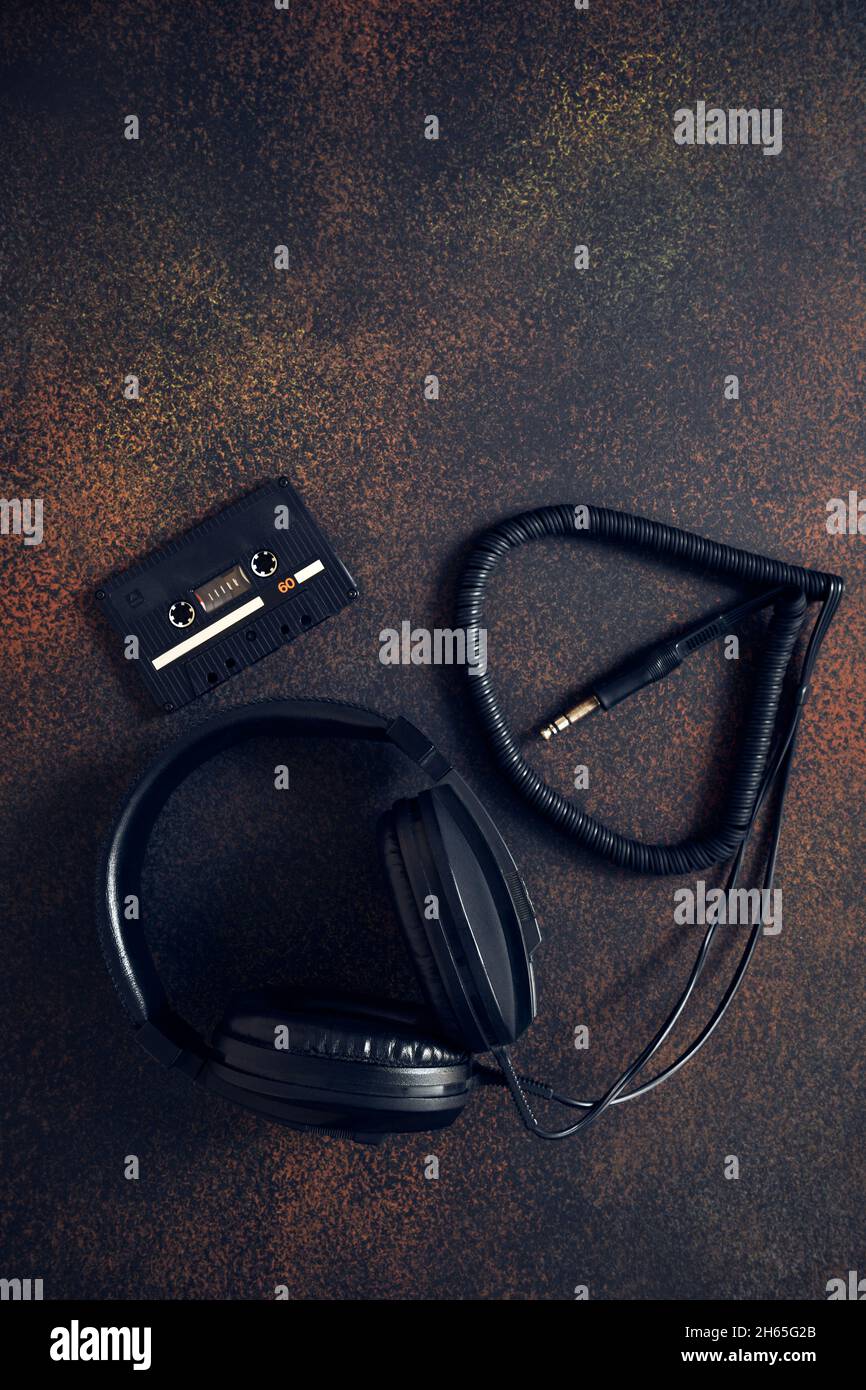 Vintage professional headphones and audio cassette. Big black headset ...