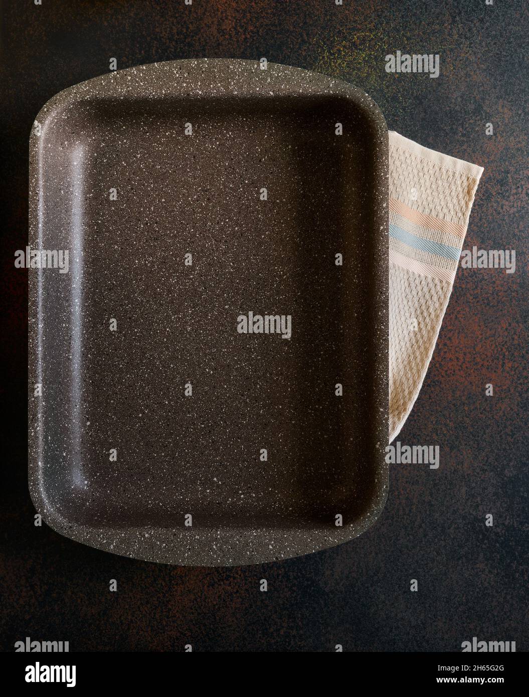 Empty baking tray with non-stick granite coating on dark background ...