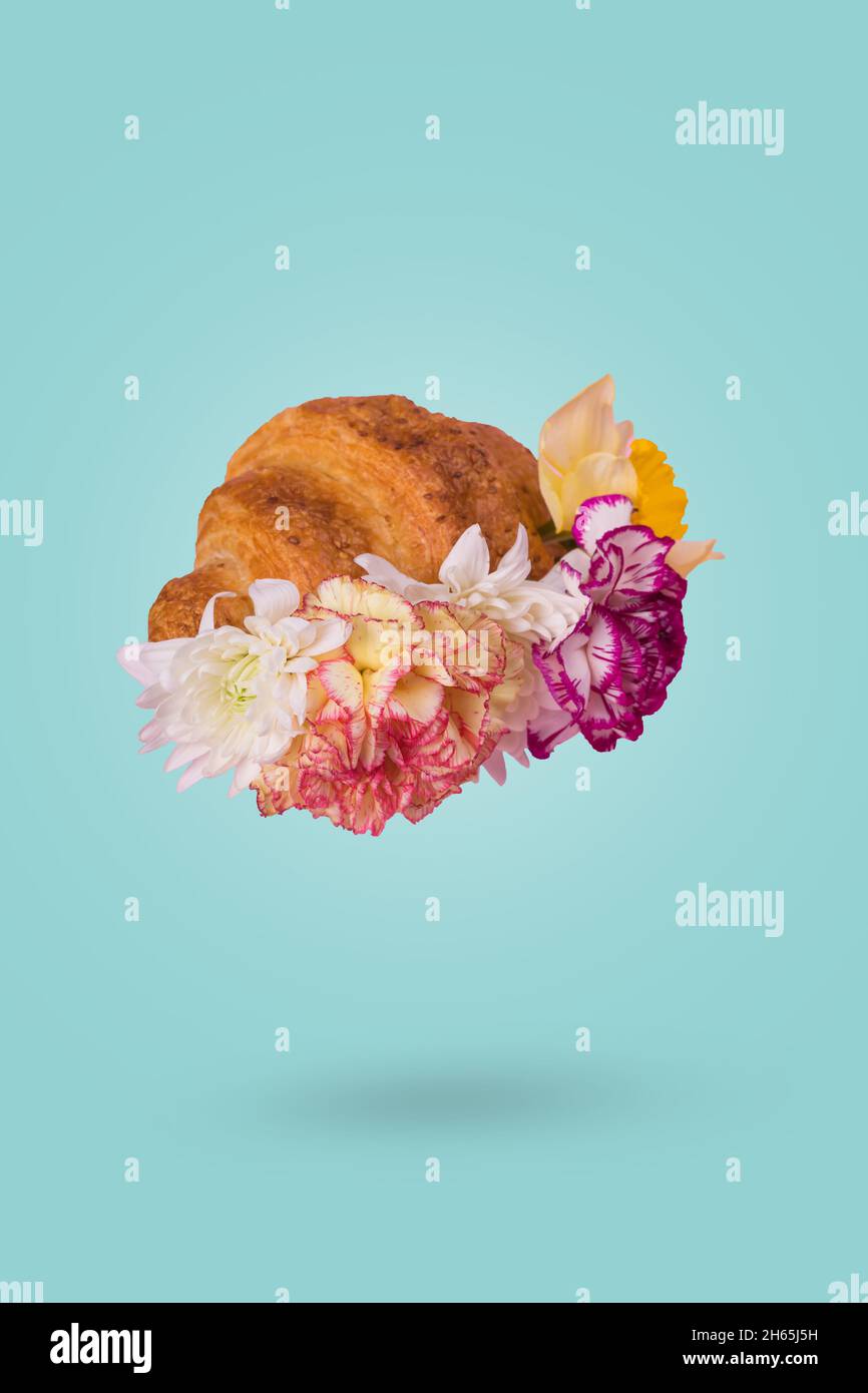 Croissant with many different colorful flowers floating in air isolated ...
