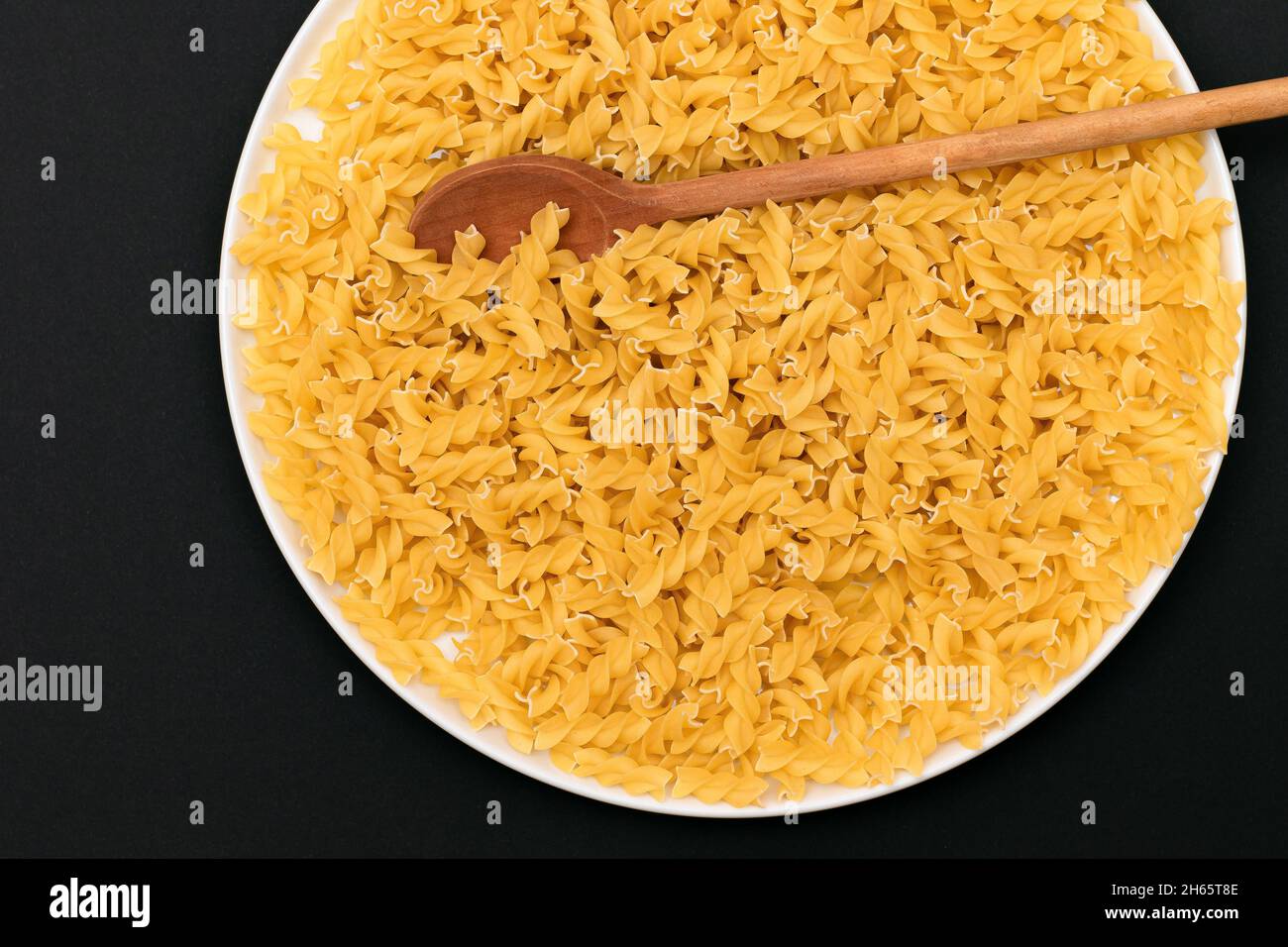 Uncooked Fusilli Pasta with Wooden Spoon. Raw and Dry Macaroni ...