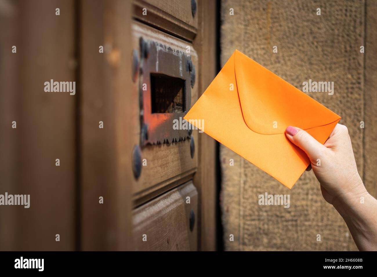 Woman sending love letter. Female hand inserting envelope into mail ...