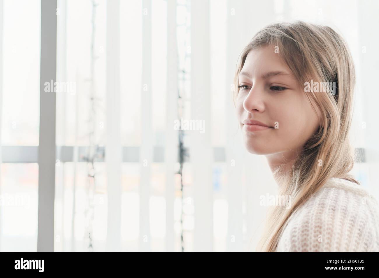 calm and peaceful teenager girl sitting in front of a window. beautiful ...