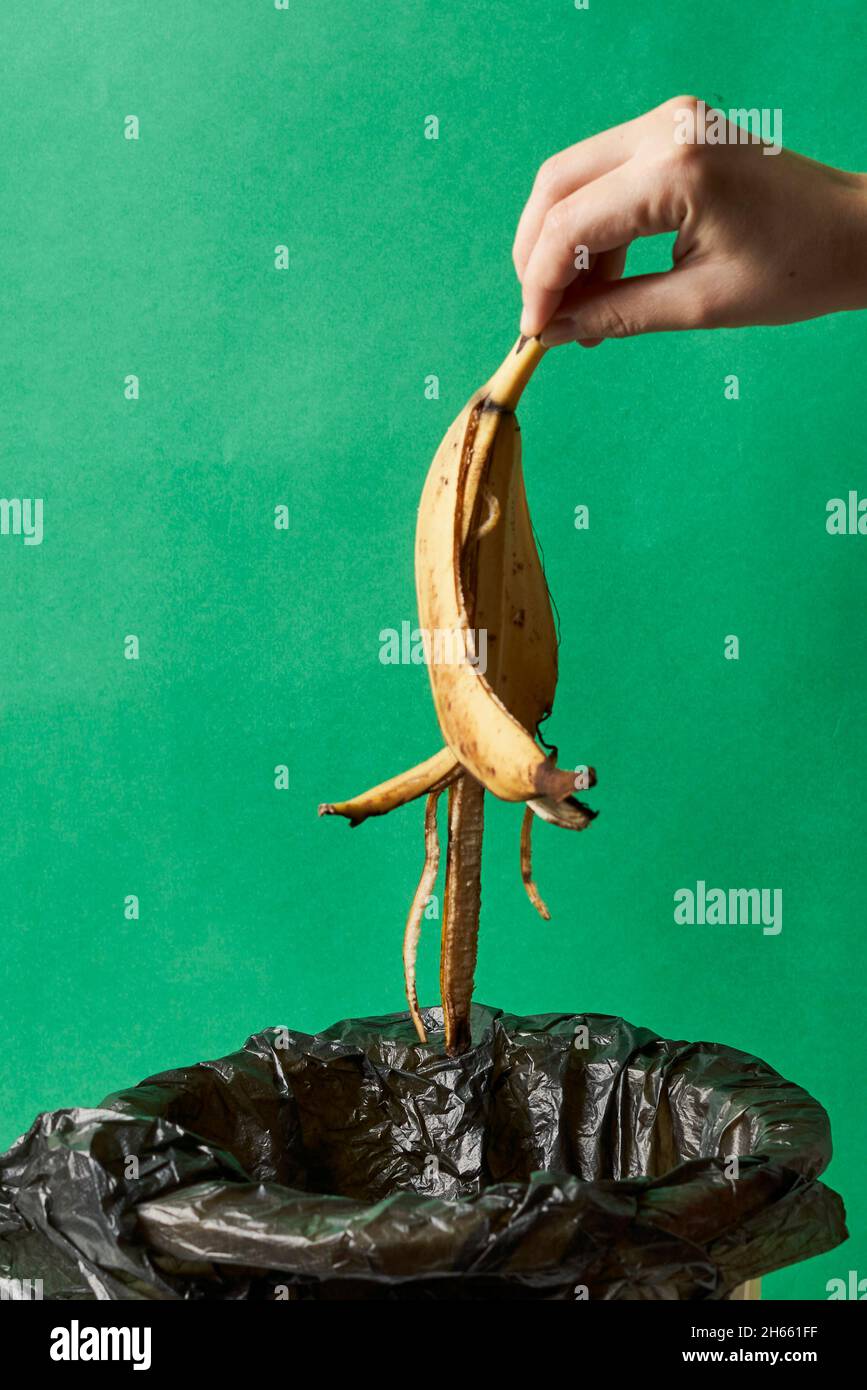 Woman throwing banana peels in trash can. Throw out banana peels in ...
