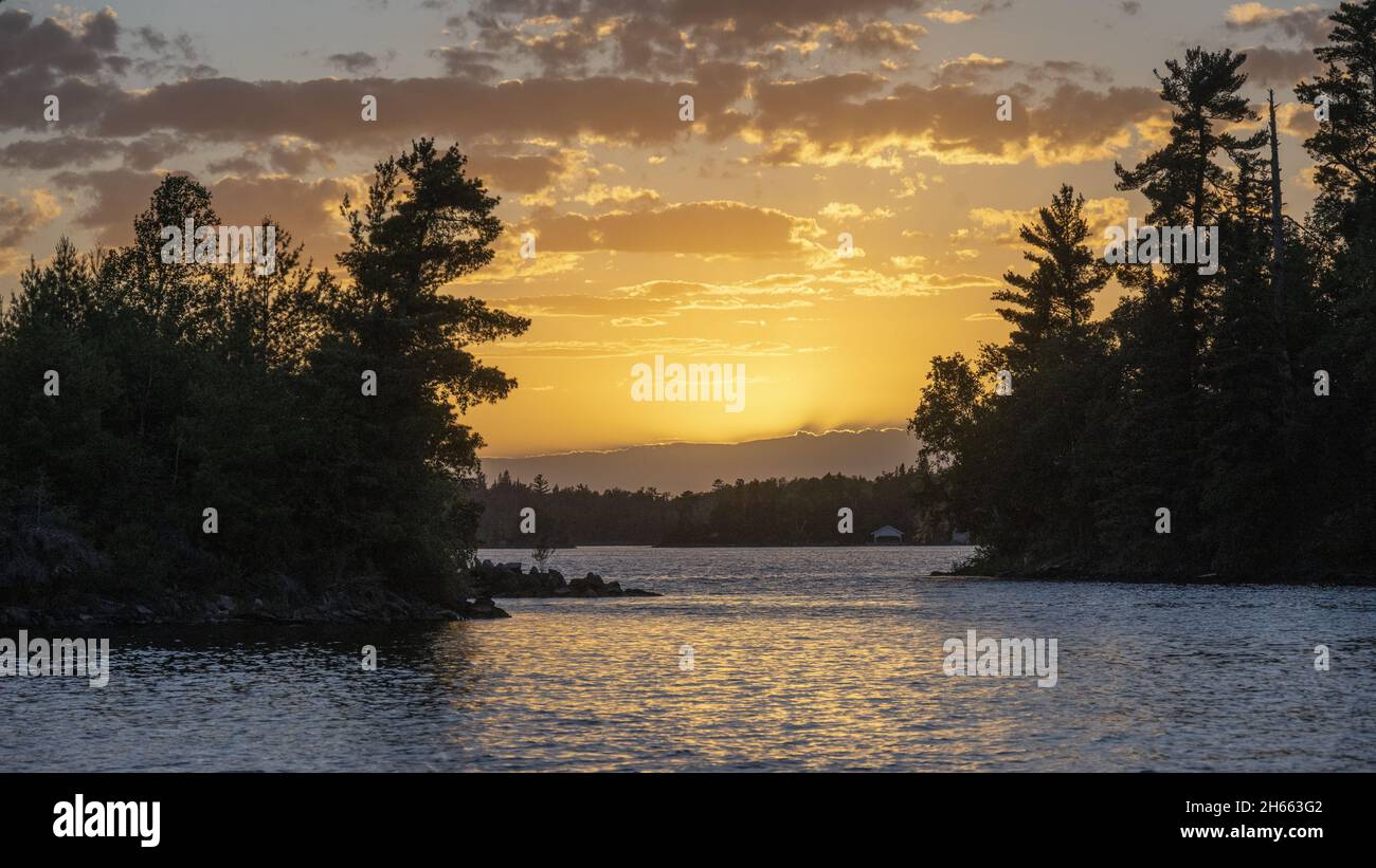 Beautiful view of a lake, pine trees on the sunset sky background Stock Photo - Alamy
