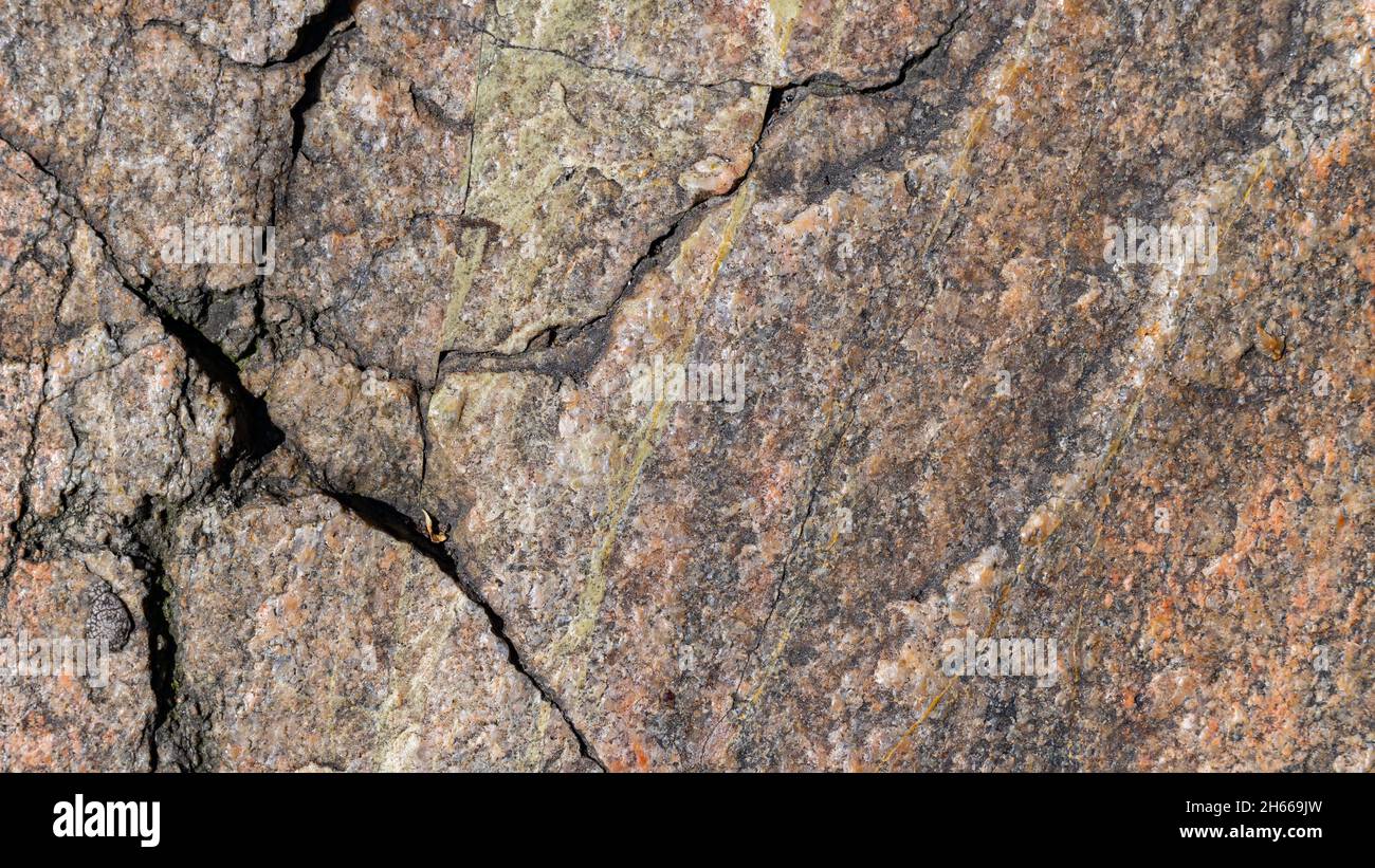 Granite rock texture. Cracked granite surface from weathering. Close-up of stone surface. Earth ...