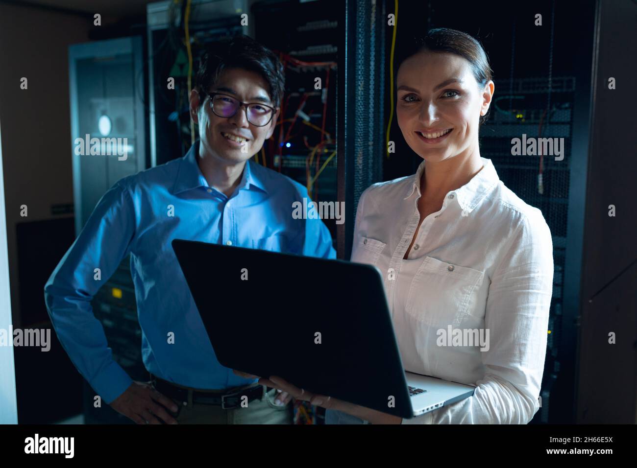 Portrait of diverse male and female engineers with laptop smiling in ...